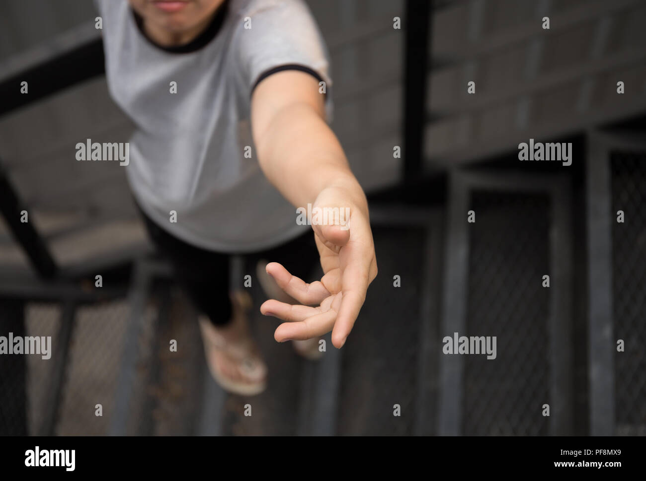 Help concept young woman hand reaching up Stock Photo - Alamy