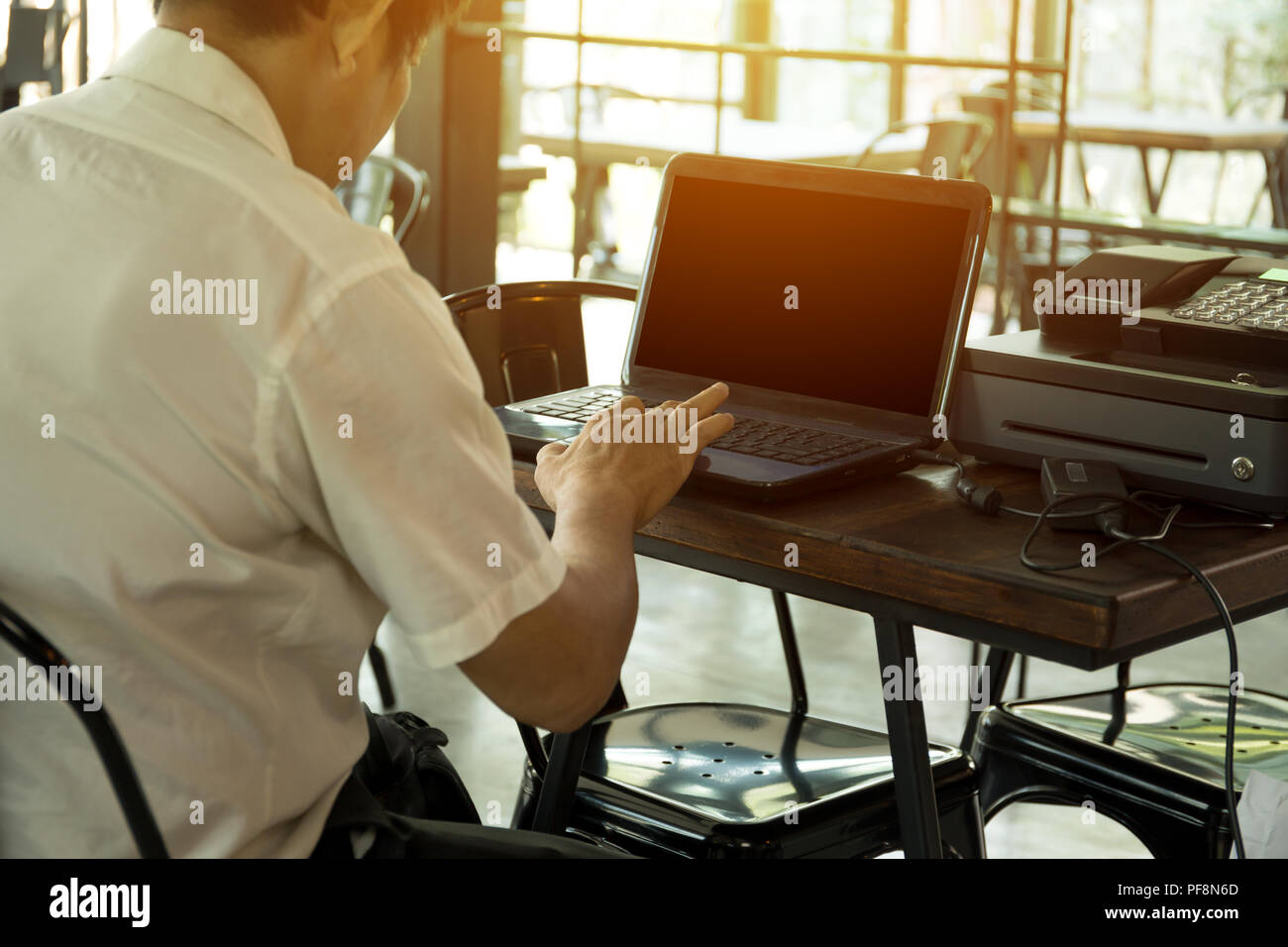 Cashier operating man set up cash register with notebook Stock Photo ...