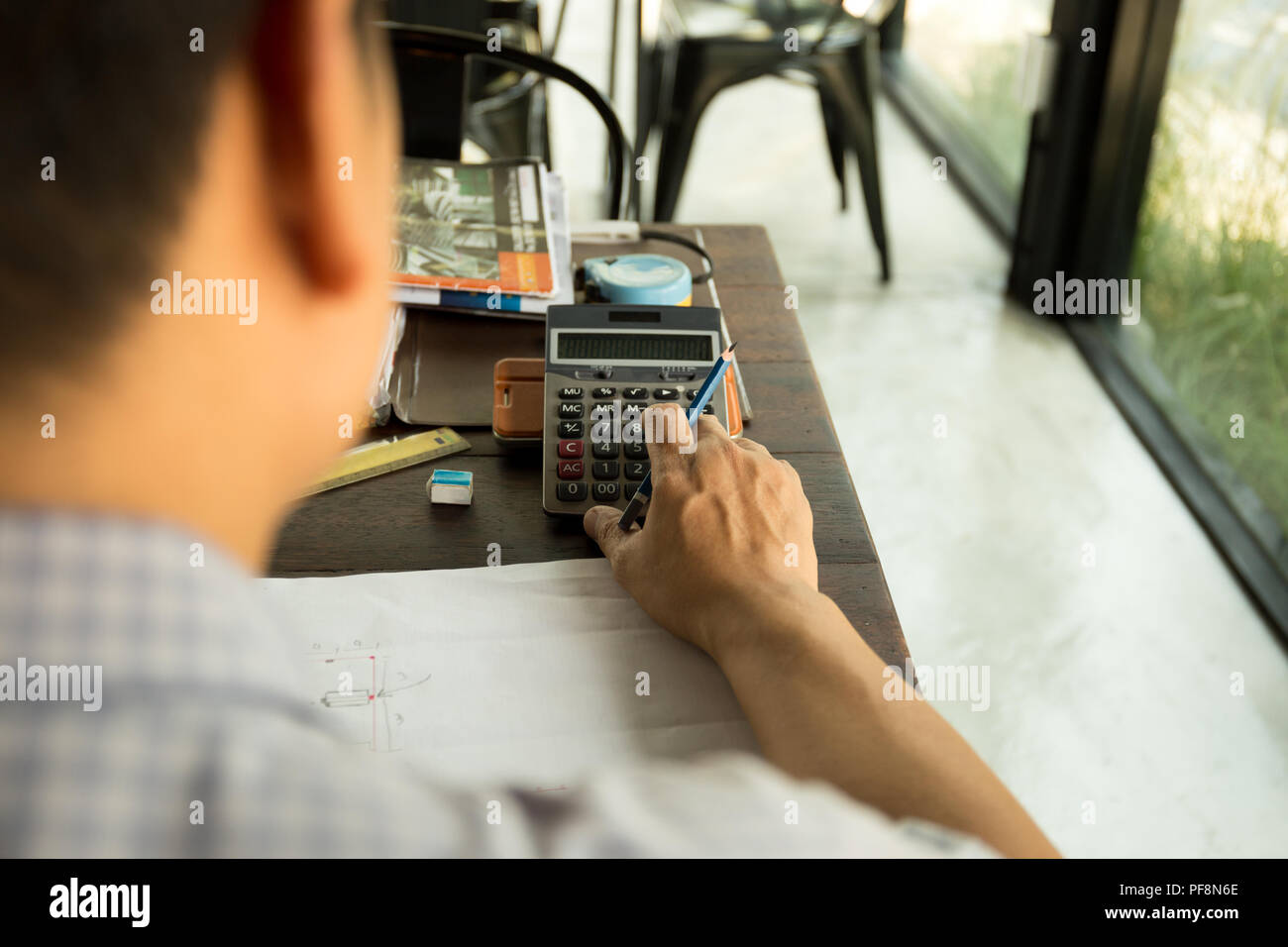 Architect with hand holding pencil and calculator project cost Stock ...