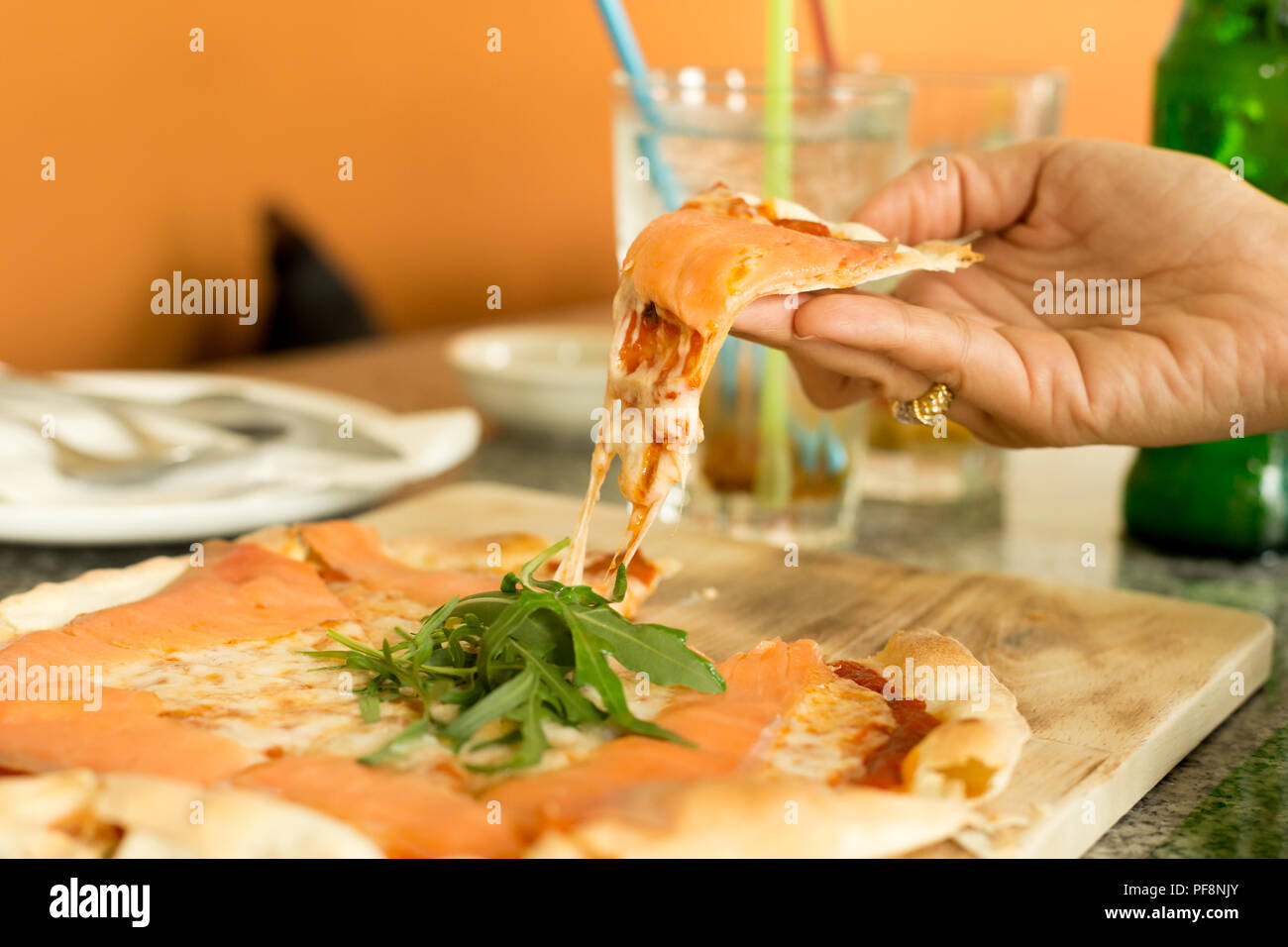 Hand pick up hot pizza slice with melted cheese and vegetable Stock ...