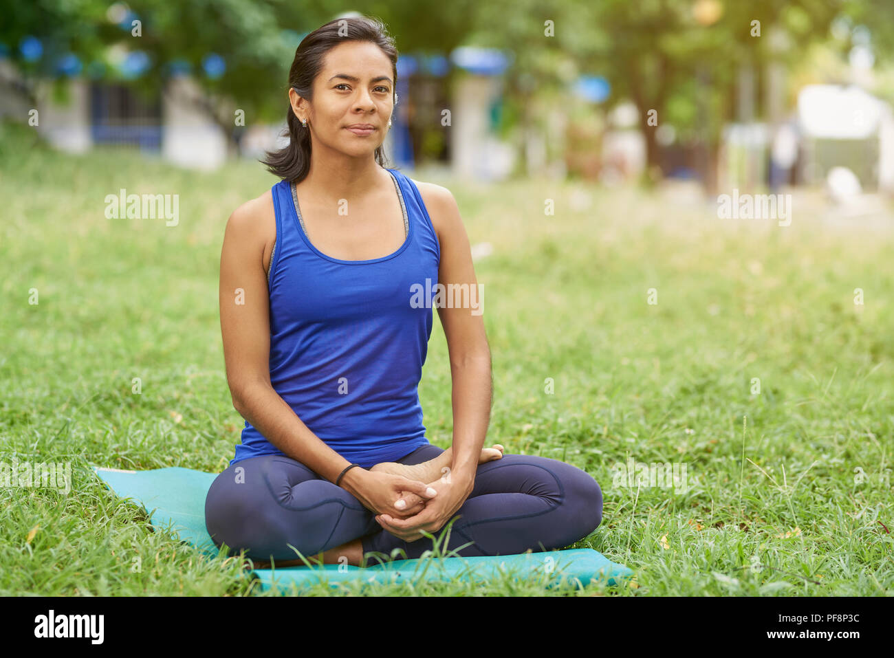 Young woman sit in relax pose on blurred natural park background Stock ...