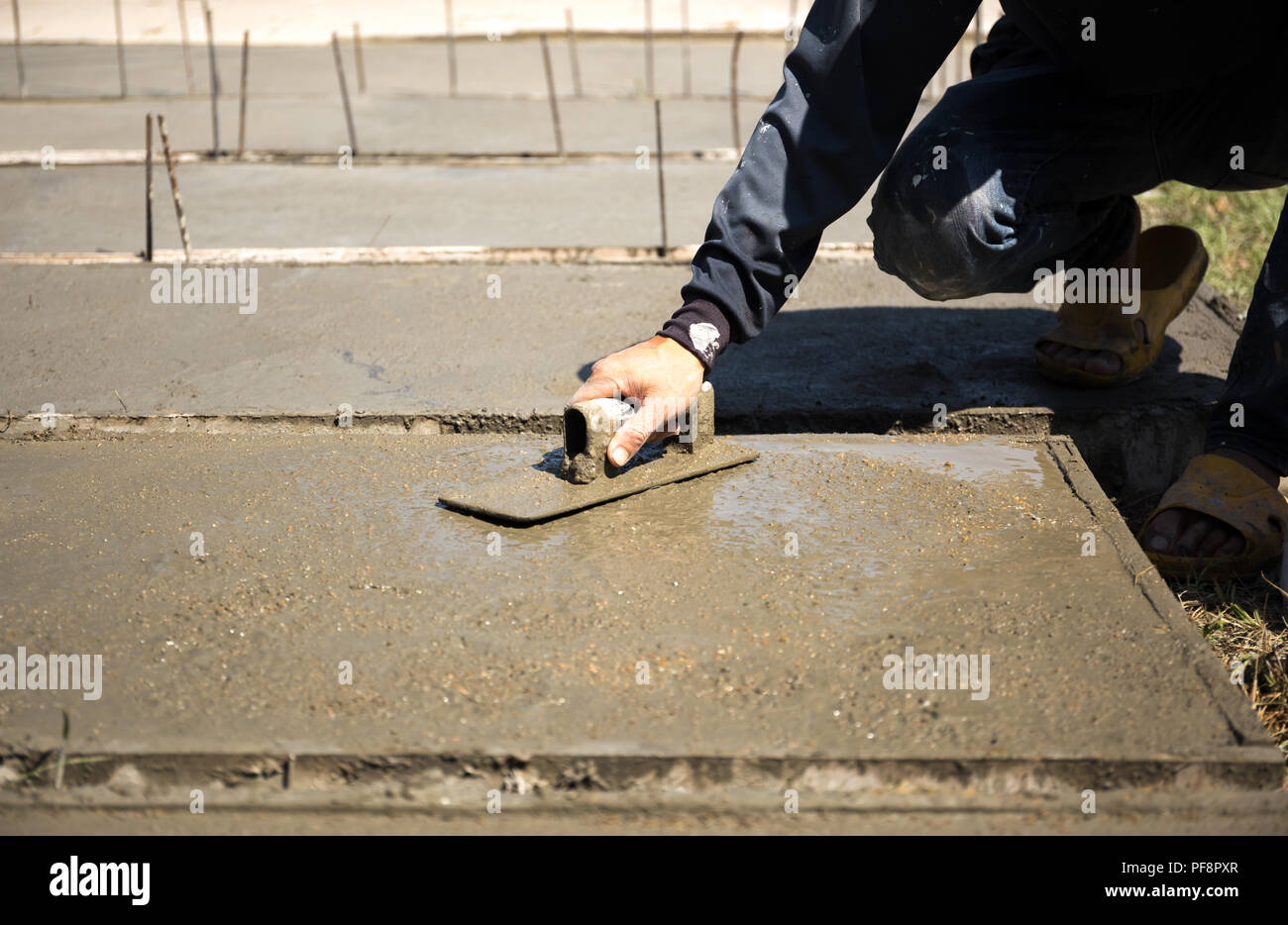Worker hand using steel trowel making concrete floor Stock Photo - Alamy