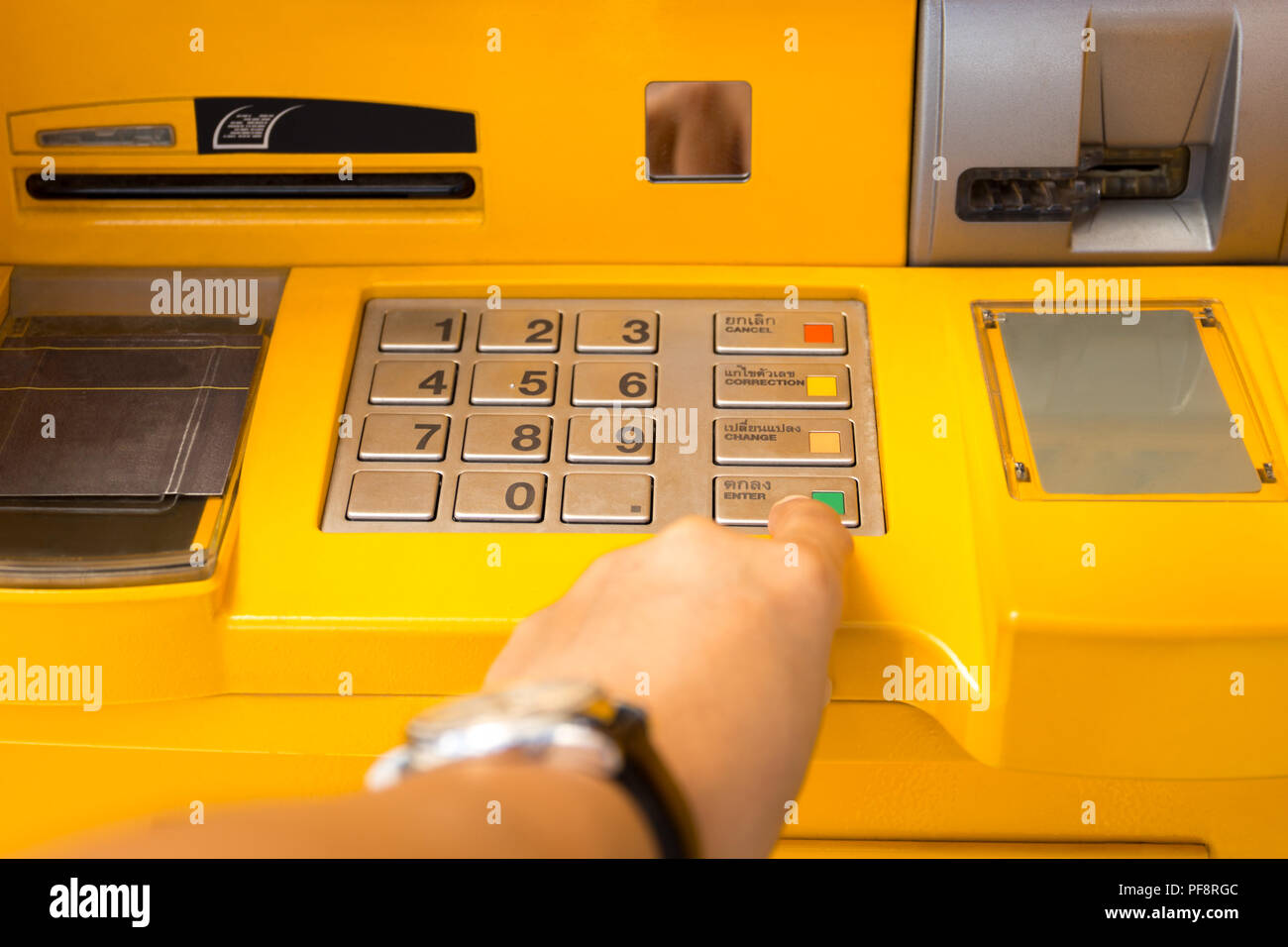 Hand pressing enter button on ATM bank machine Stock Photo - Alamy