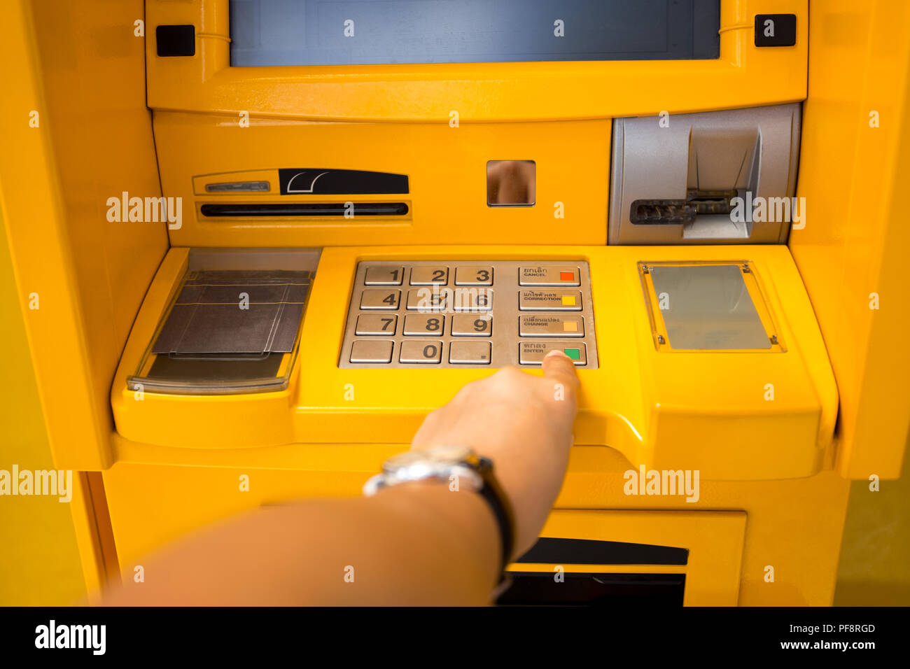 Hand pressing enter button on ATM bank machine Stock Photo - Alamy
