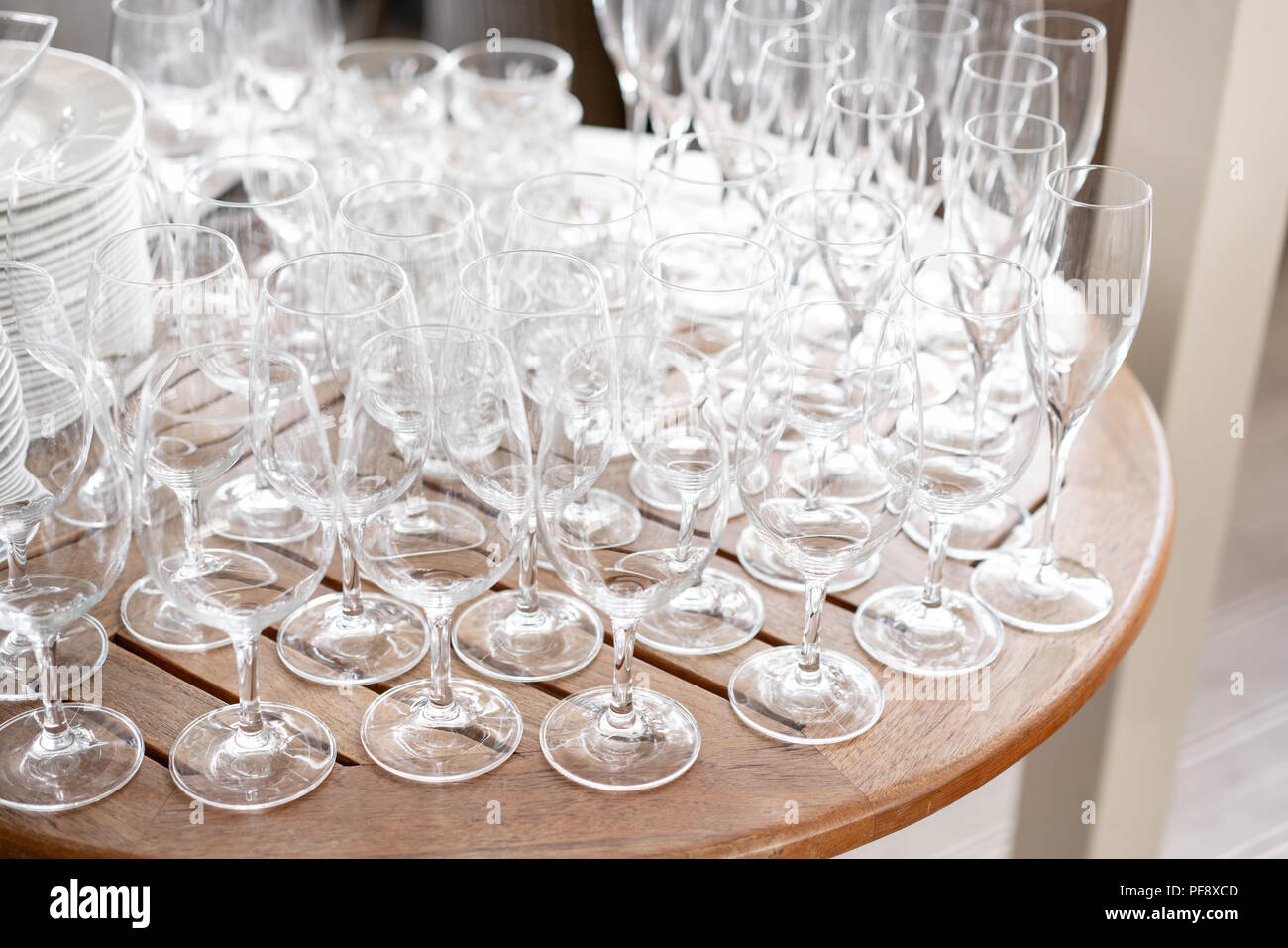 Clean plates, glasses and cutlery on wooden table. Catering set-up ...