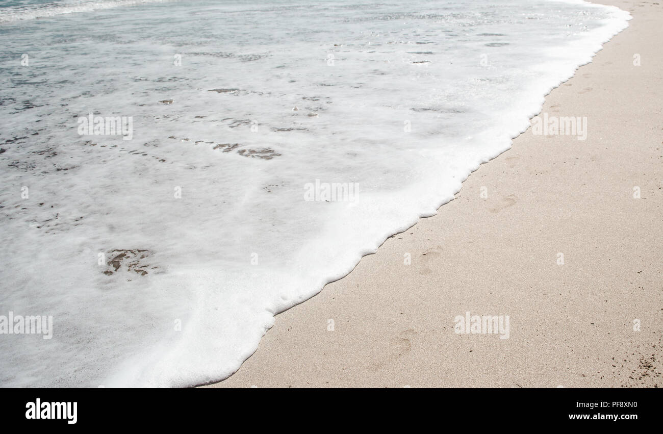 Frothy white water waves washing up on a white sandy paradise beach ...