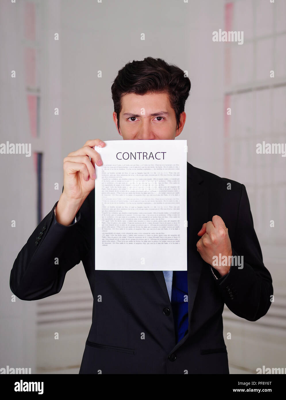Close up of happy businessman wearing a suit and holding a sheet of ...