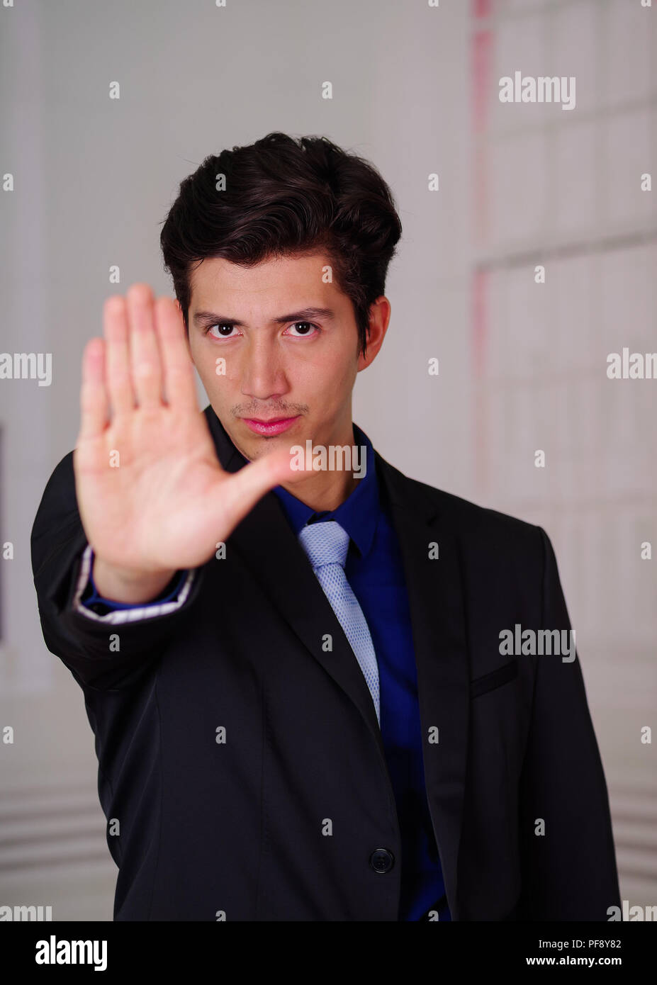 Close up of boss wearing a suit with his open hand pointing in front of ...