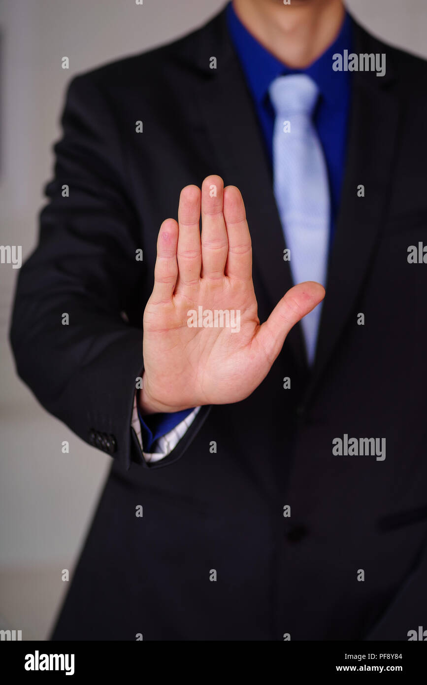 Close up of man wearing a suit with his open hand pointing in front of ...