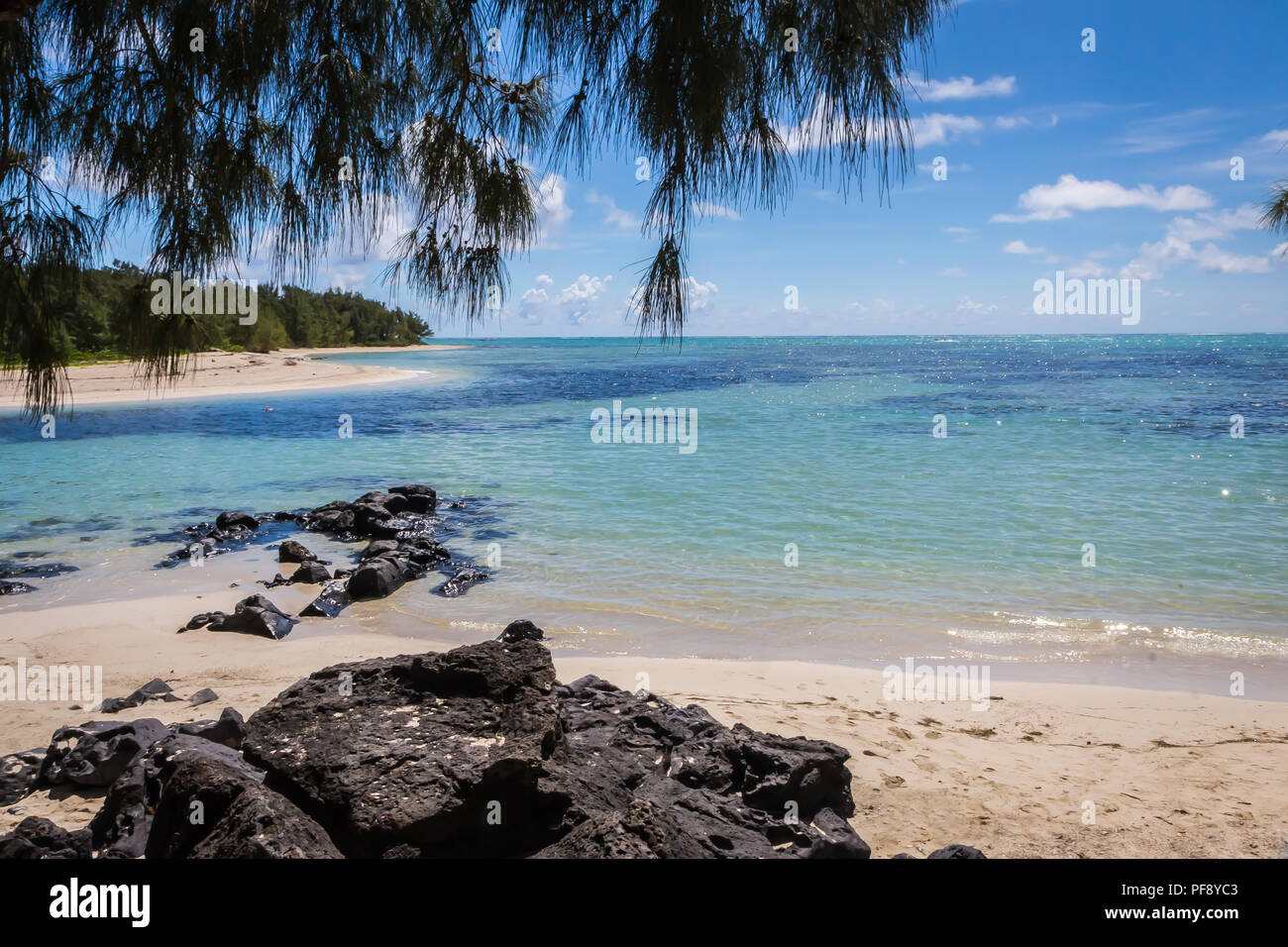 blue ocean and black lava stones on a sandy beach of volcanic island ...