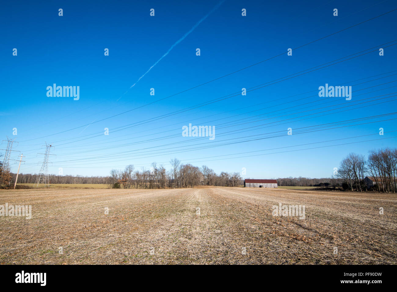 Power lines drape over the empty fields of a grain farm in the winter ...