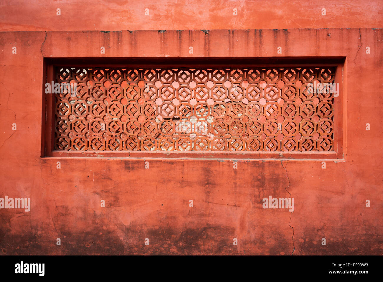 Vermilion wall background with beautiful opening to let light pass ...