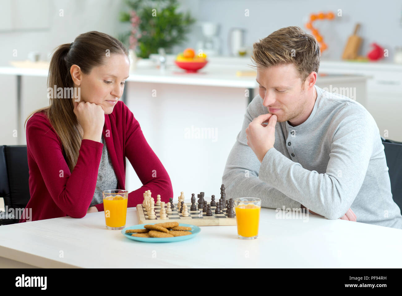 young happy couple playing chess at a home interior Stock Photo - Alamy