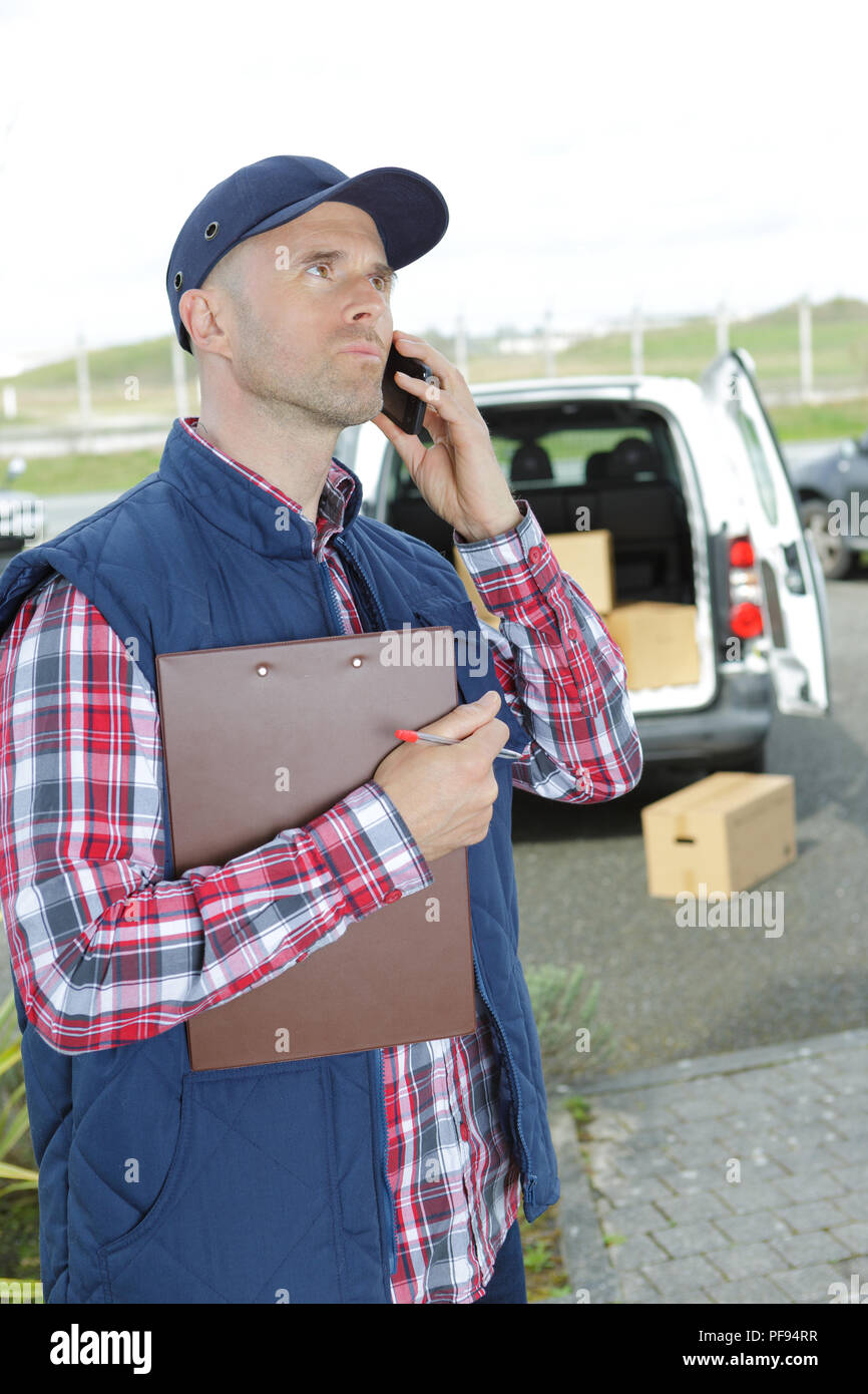 Delivery driver using telephone Stock Photo - Alamy