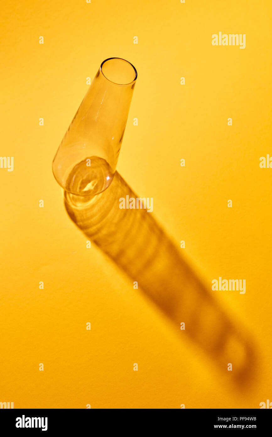 The glass transparent bottle with reflection on a yellow paper ...