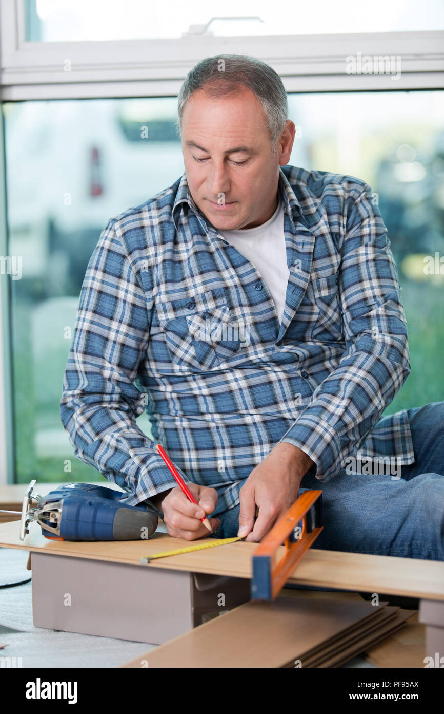 male carpenter use measuring tape measure wood Stock Photo - Alamy