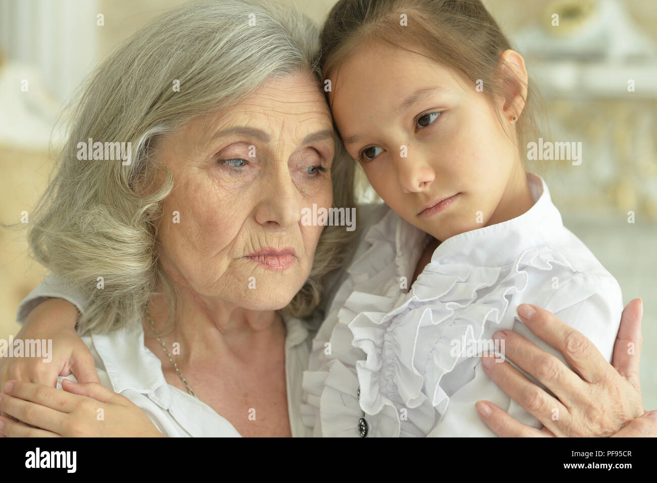 Portrait of a sad grandmother and granddaughter hugging Stock Photo - Alamy