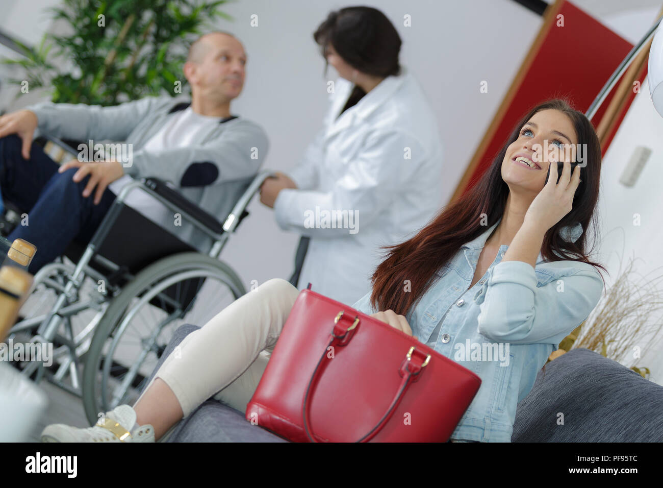 woman in clinic waiting room speaking at phone smiling Stock Photo - Alamy