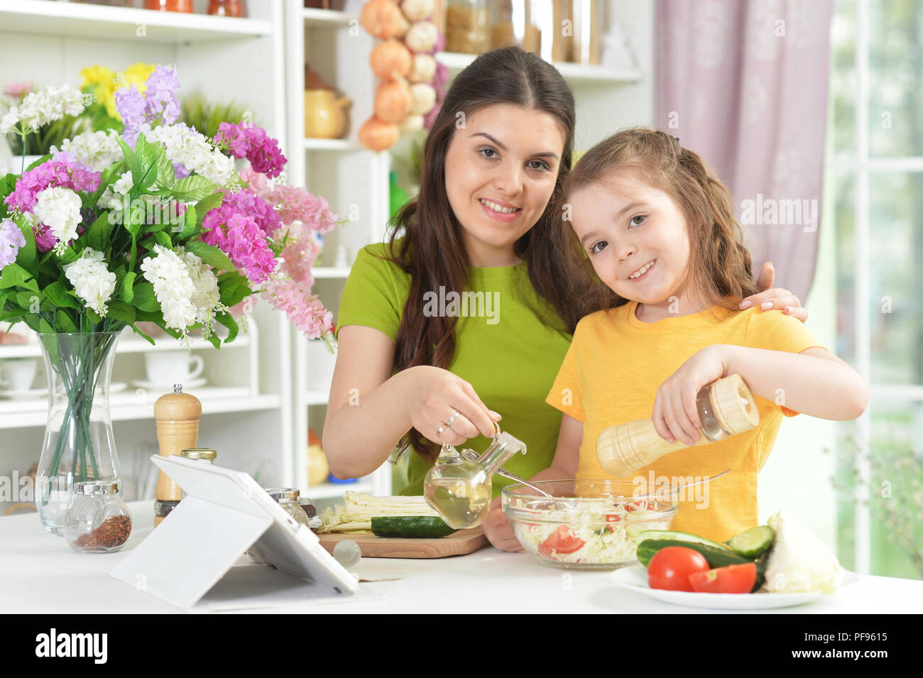 Cute little girl with her mother cooking together Stock Photo - Alamy