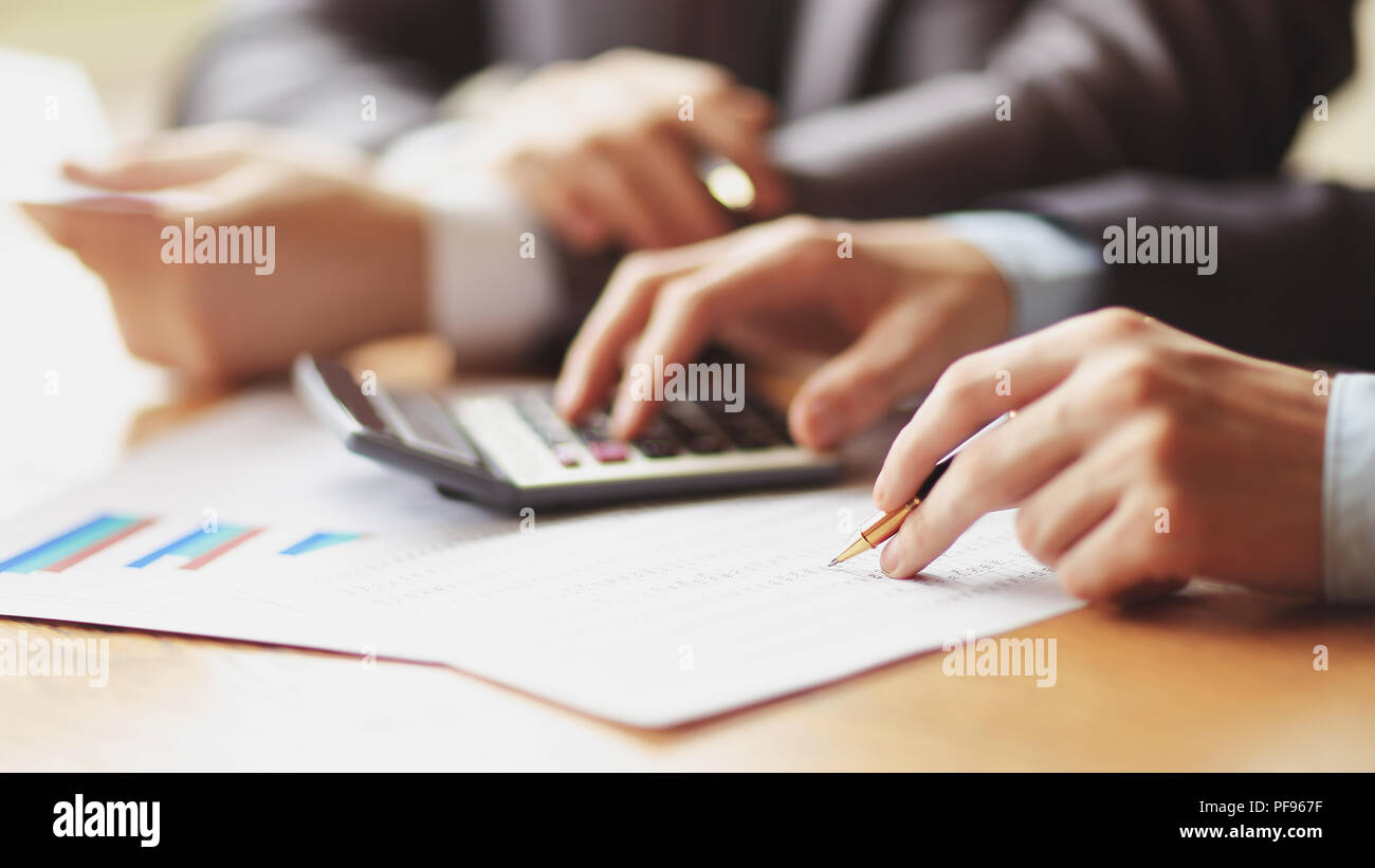 Close up of businessman or accountant hand holding pencil working on ...
