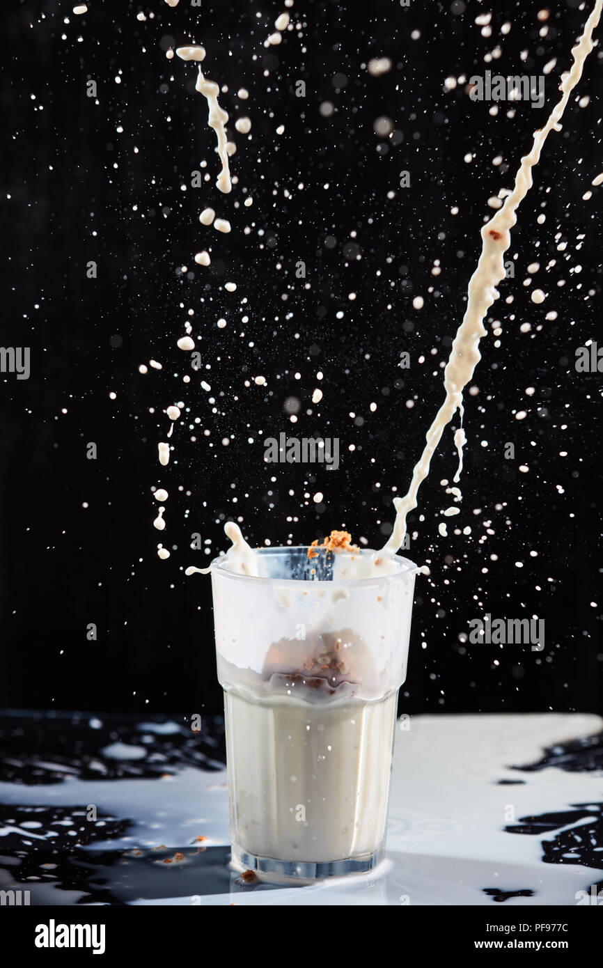 Sprays and drops of milk fly in different directions and the milk ...