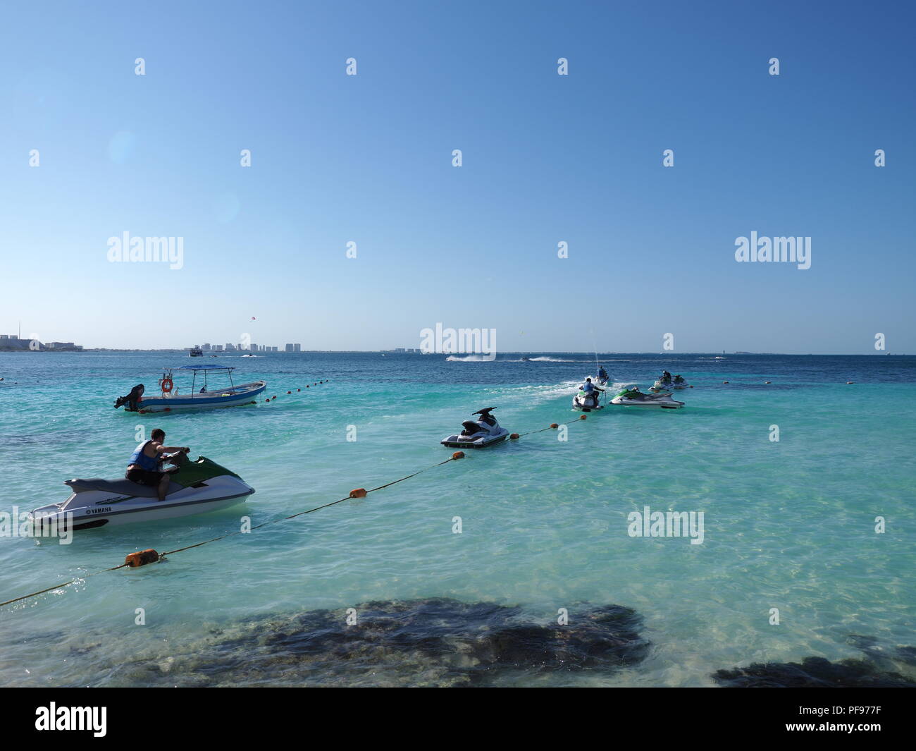 Jet skis and boats on sandy beach at bay of Caribbean Sea in Cancun ...