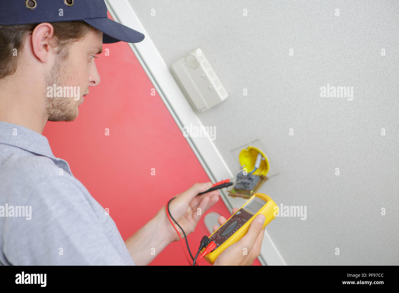 Electrician testing socket with multimeter Stock Photo - Alamy
