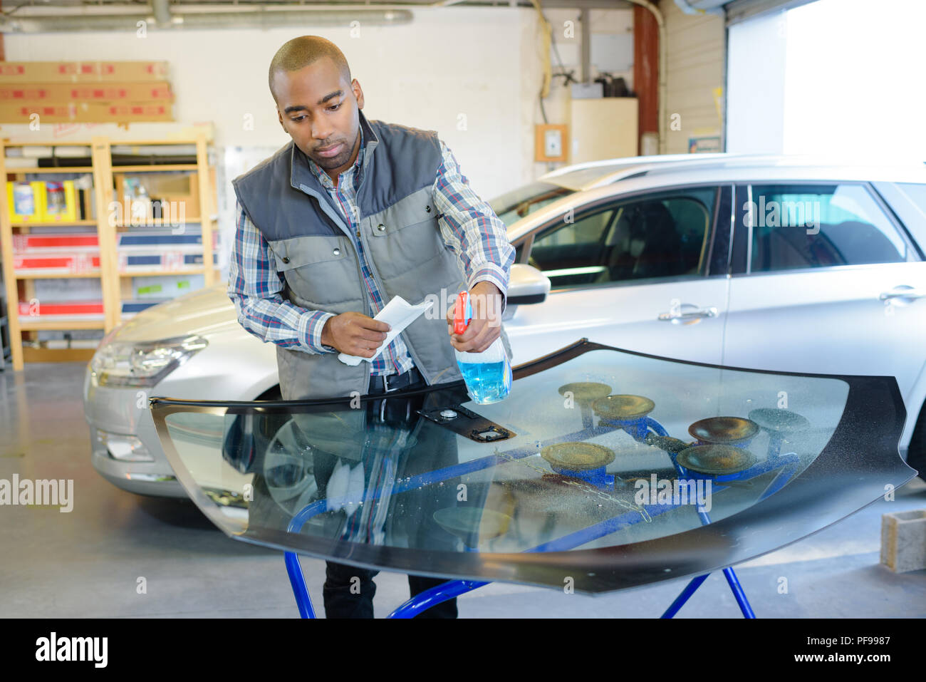 Mechanic spraying new windscreen Stock Photo - Alamy