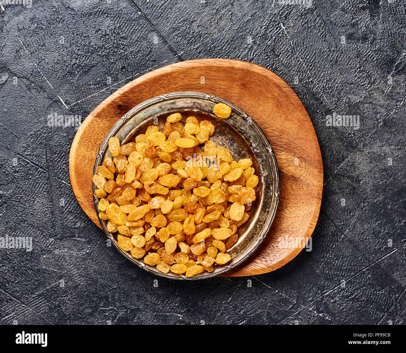 Yellow raisins on black concrete background. Top view of dried grapes ...