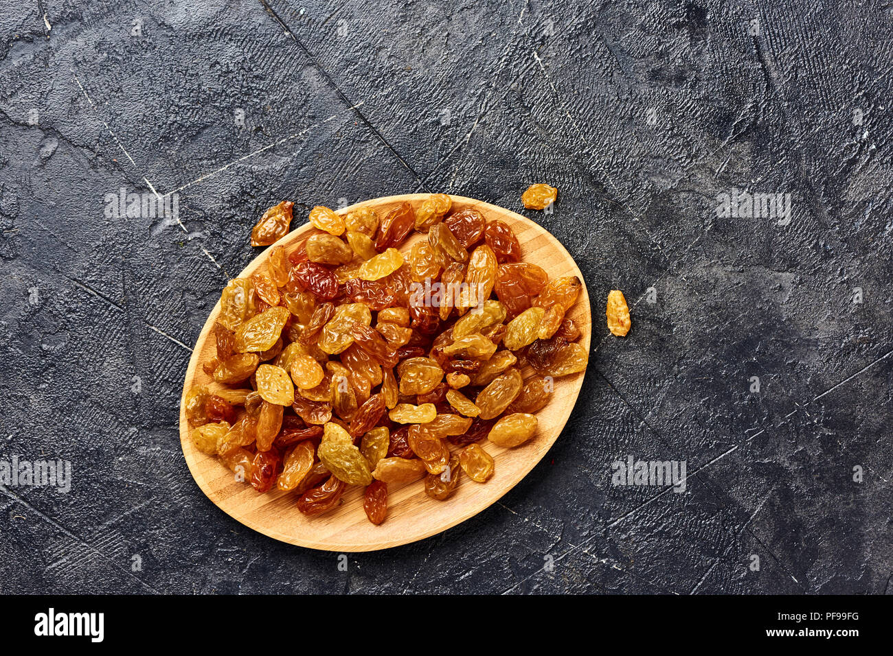 Yellow big raisins on black concrete background with copy space. Top ...