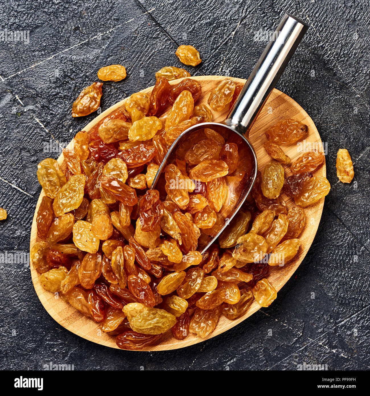 Yellow big raisins on black concrete background. Top view of dried ...