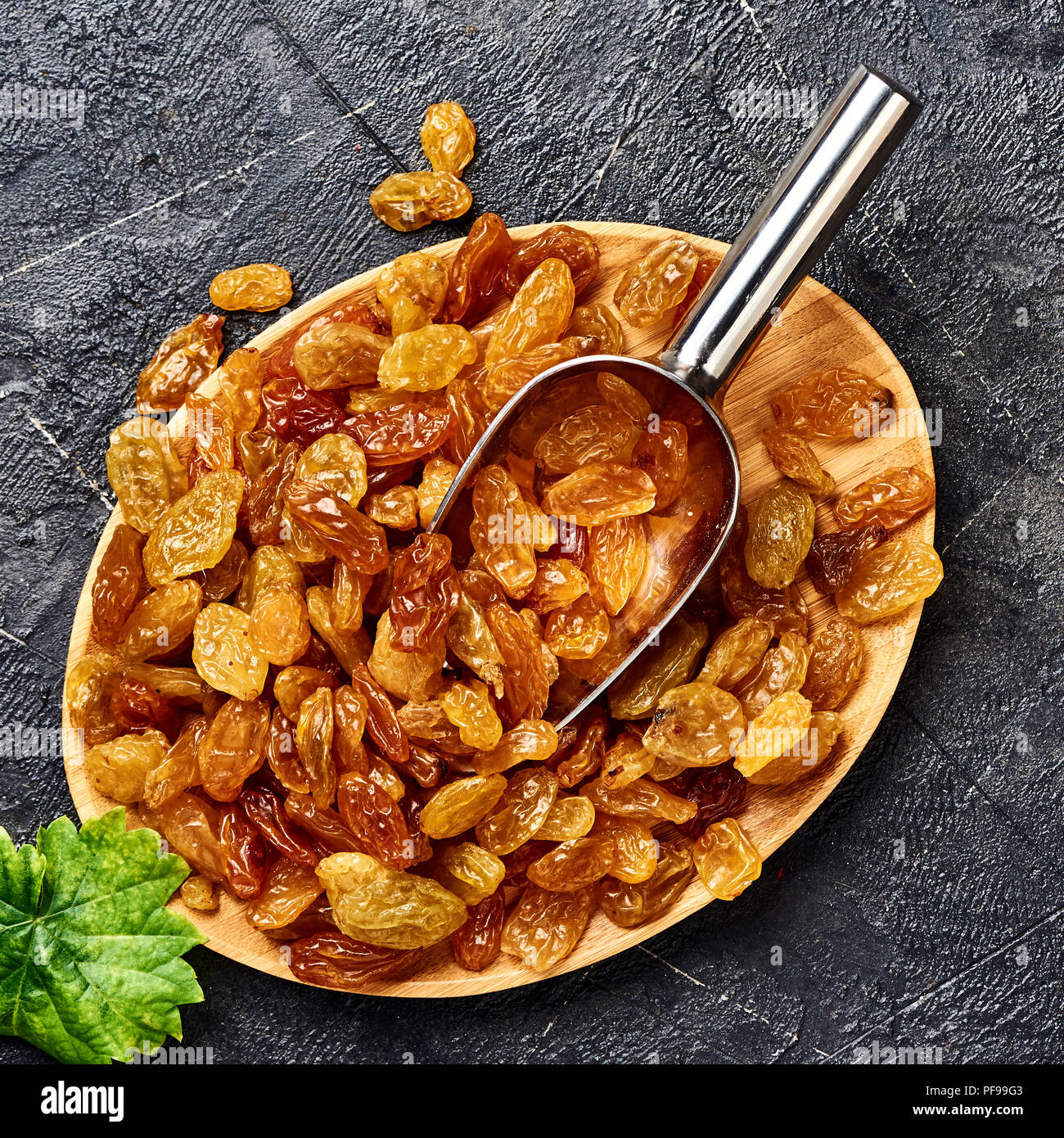 Yellow big raisins on black concrete background. Top view of dried ...