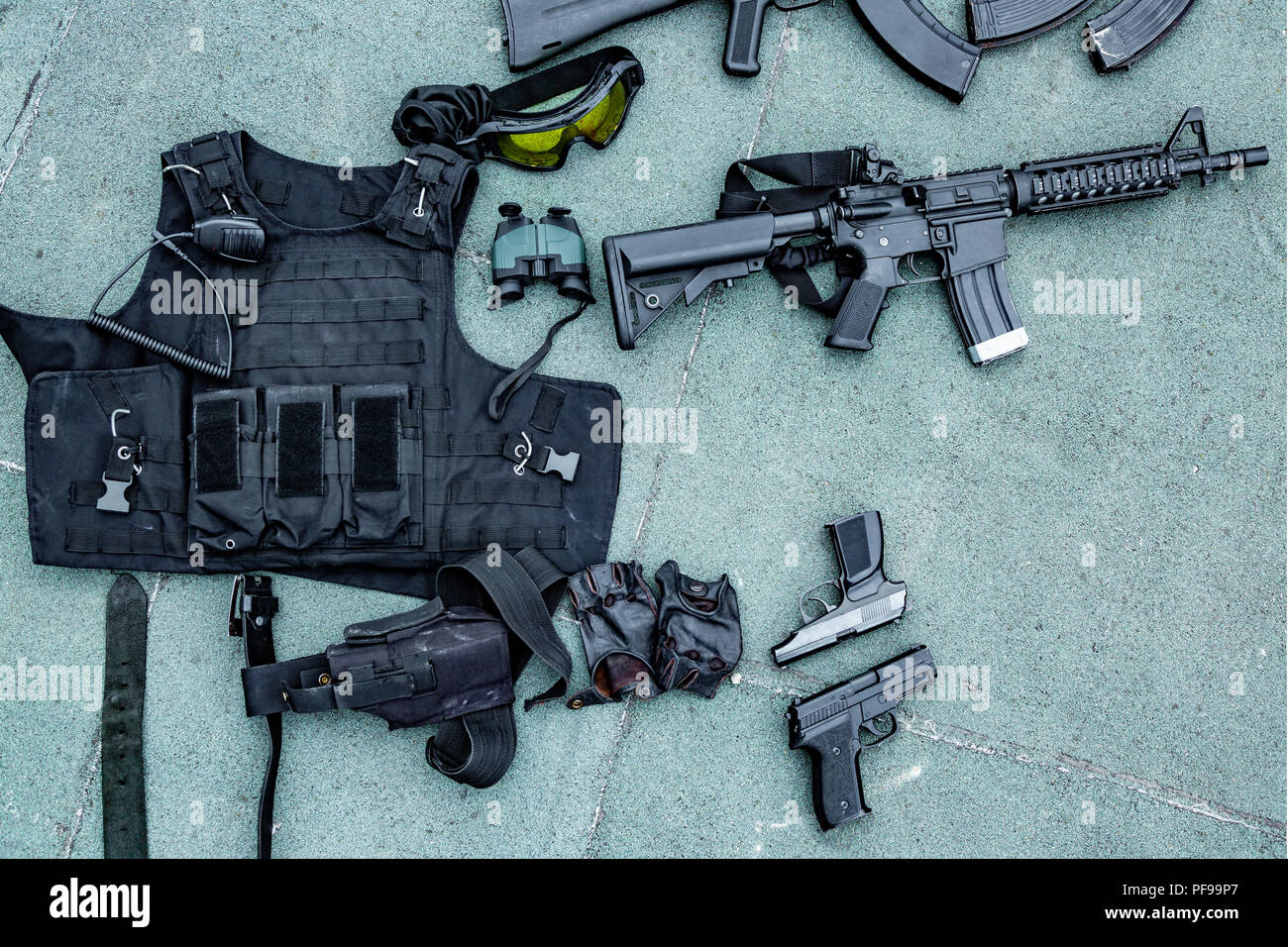 Weapons on the ground. Rifles pistols guns body armor Stock Photo - Alamy