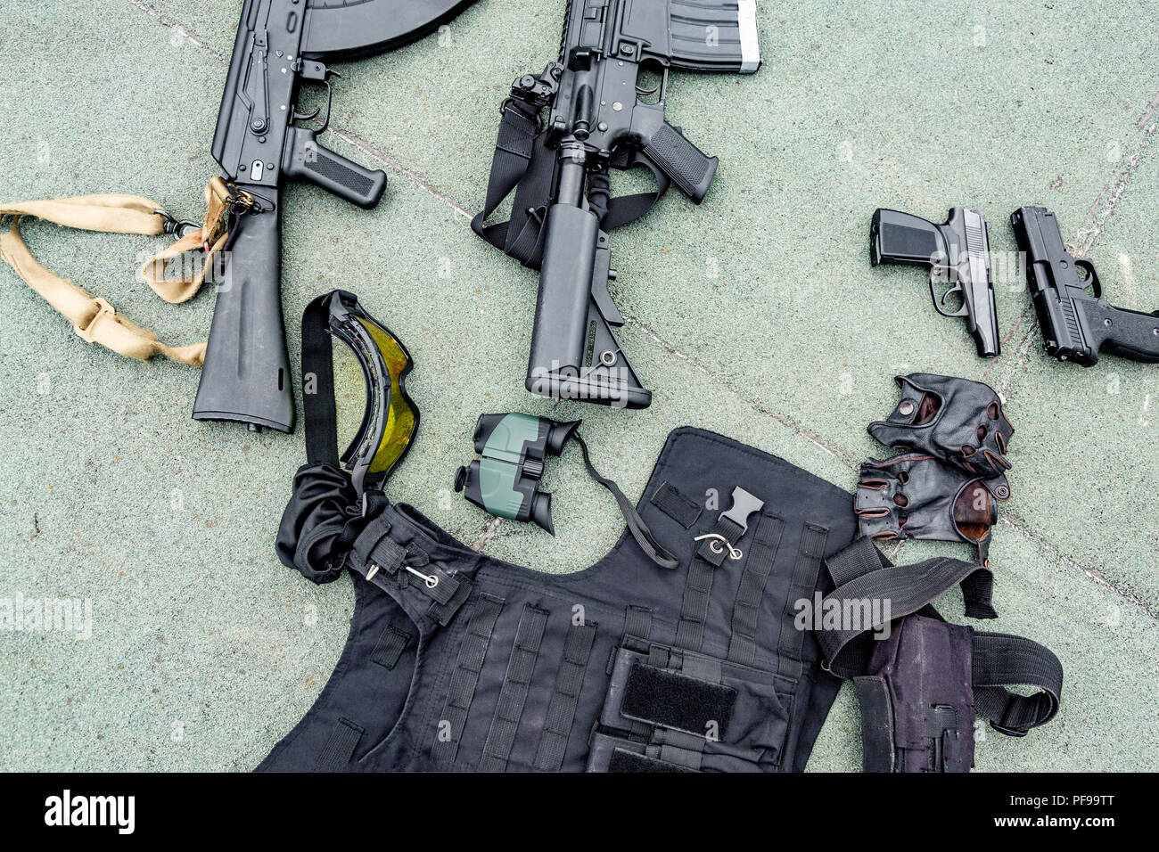 Weapons on the ground. Rifles pistols guns body armor Stock Photo - Alamy
