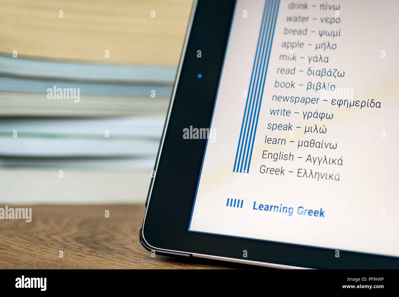Learning Greek using a tablet with books in the background Stock Photo ...