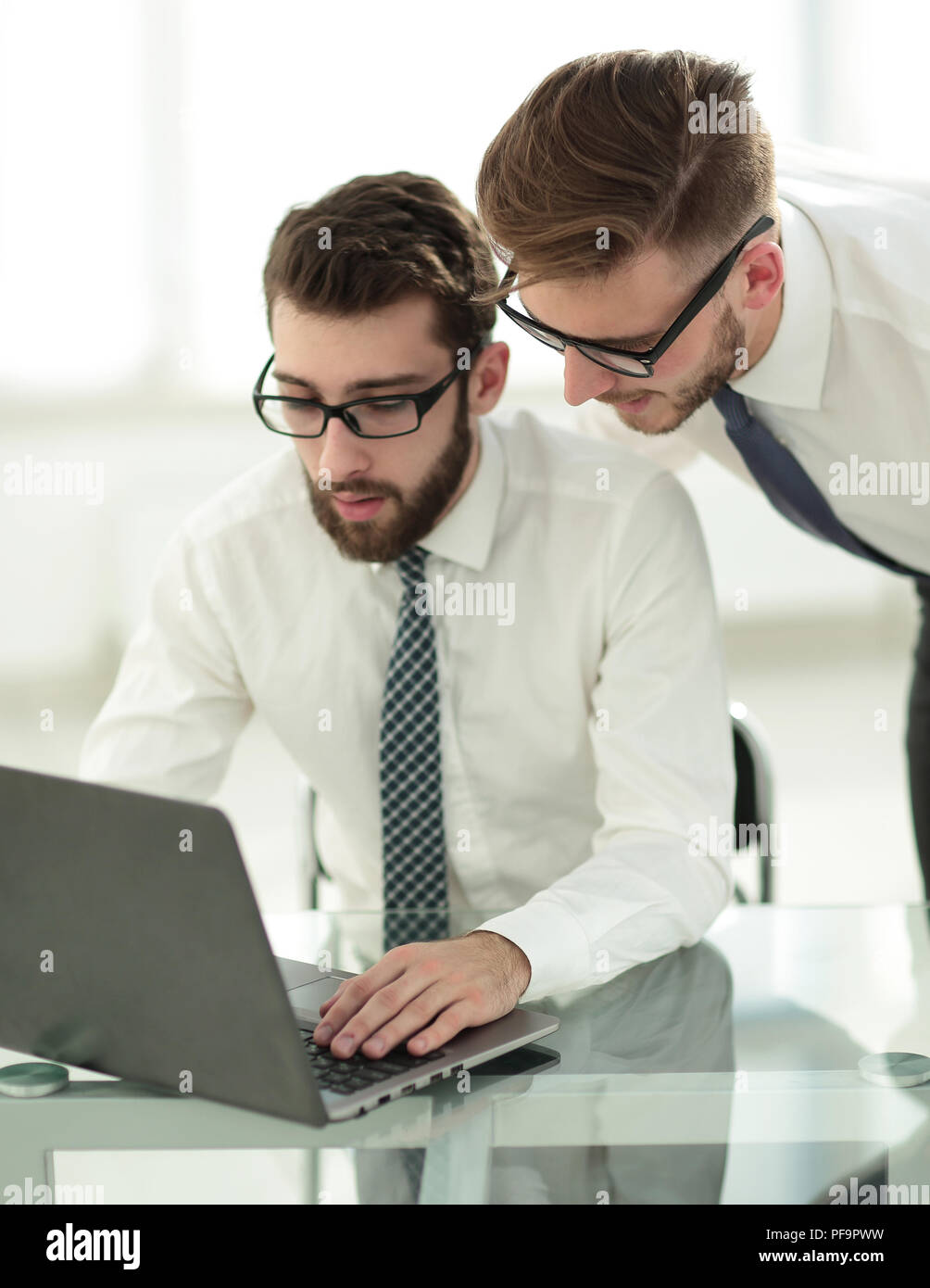 two employees using a laptop in the workplace in the office Stock Photo ...