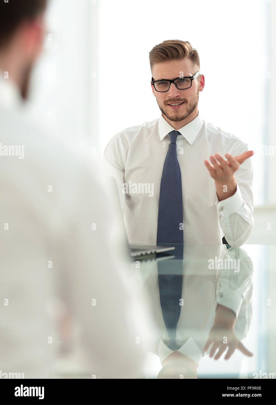 Manager talks to the employee sitting at his Desk Stock Photo - Alamy