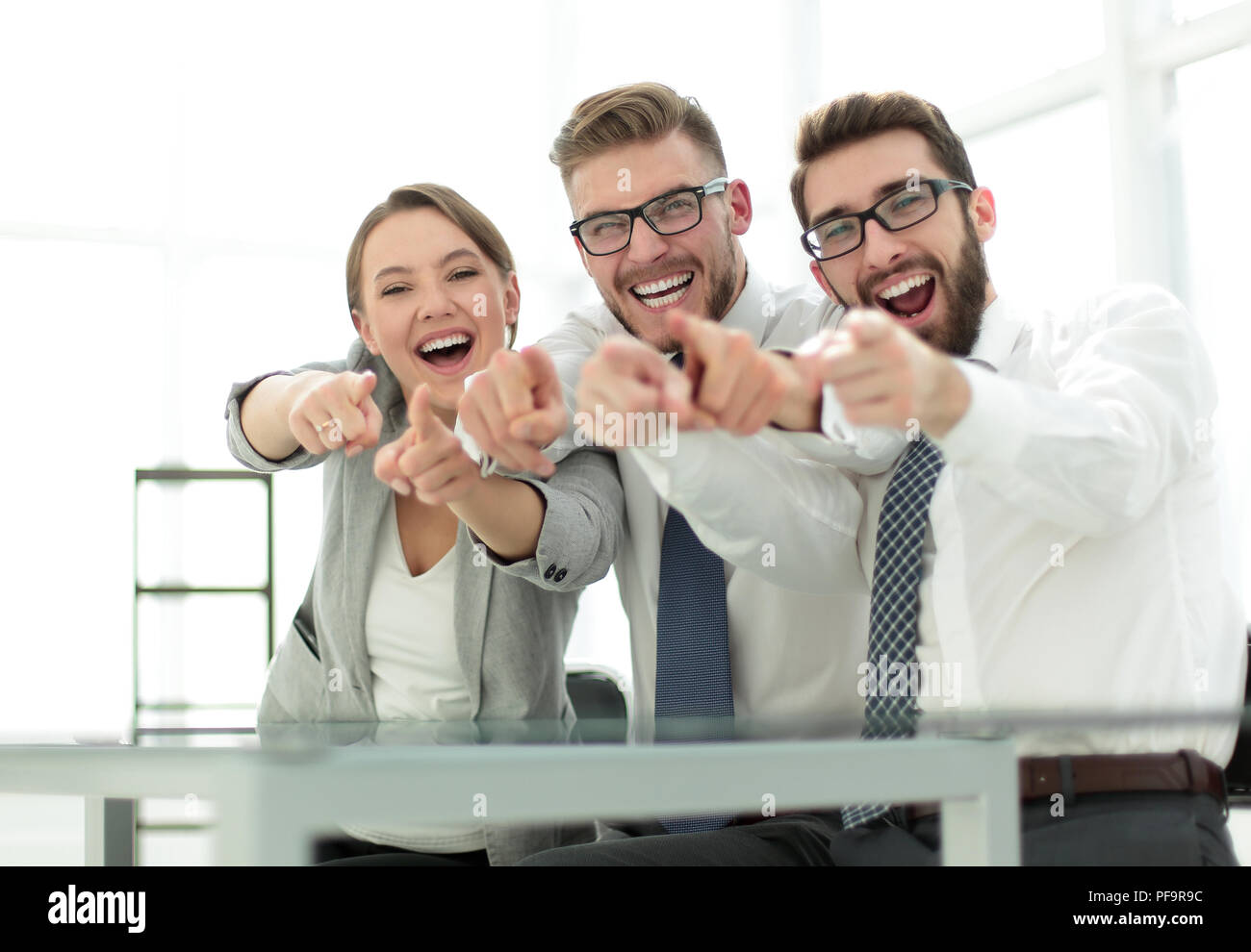 close up.a smiling business team pointing at you Stock Photo - Alamy