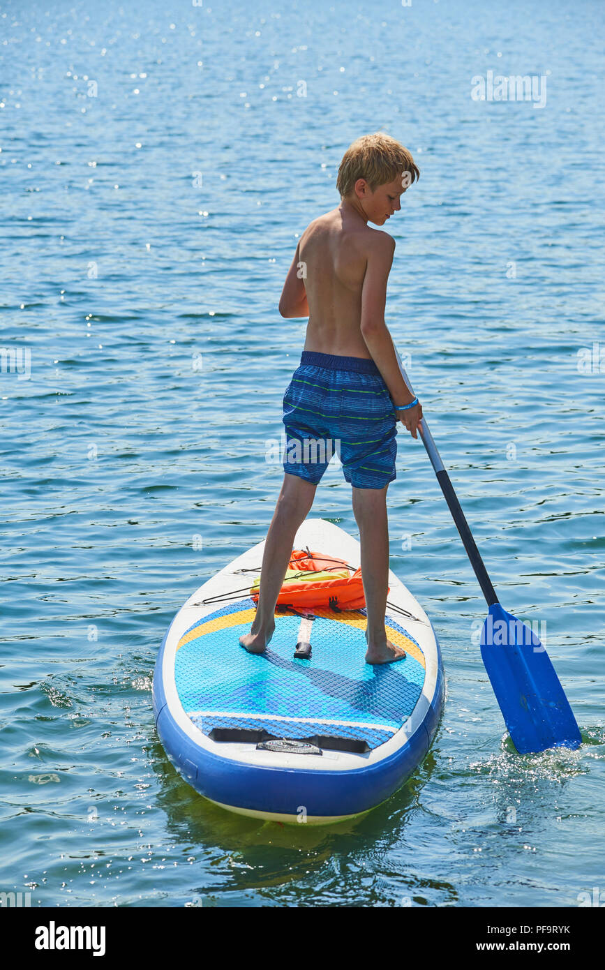 Paddle boarder. Child boy paddling on stand up paddleboard. Healthy ...