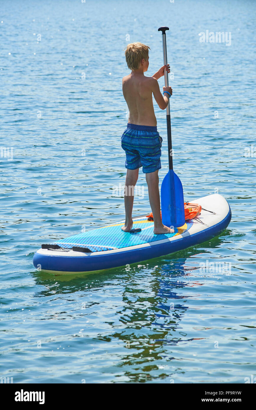 Paddle boarder. Child boy paddling on stand up paddleboard. Healthy ...
