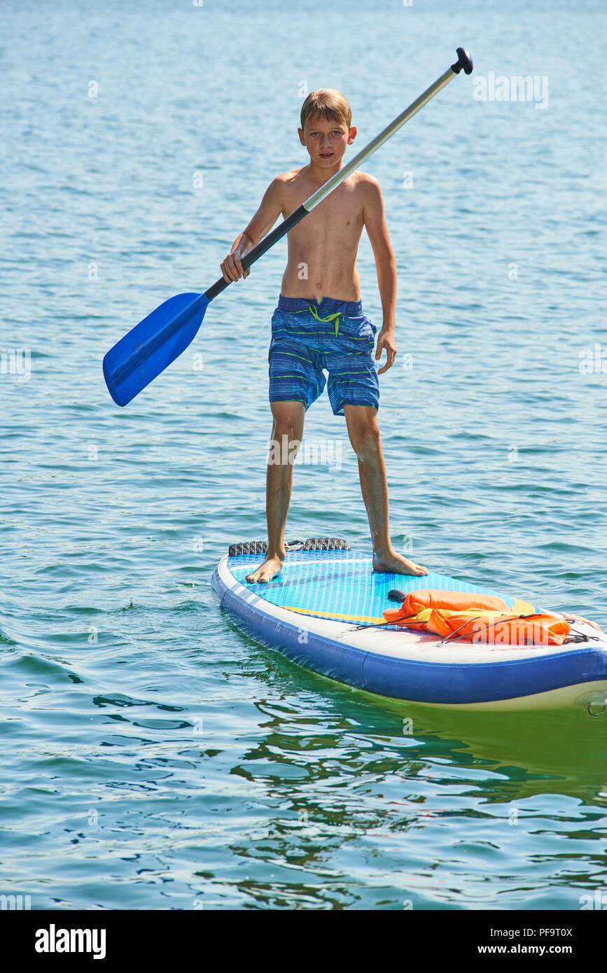 Paddle boarder. Child boy paddling on stand up paddleboard. Healthy ...