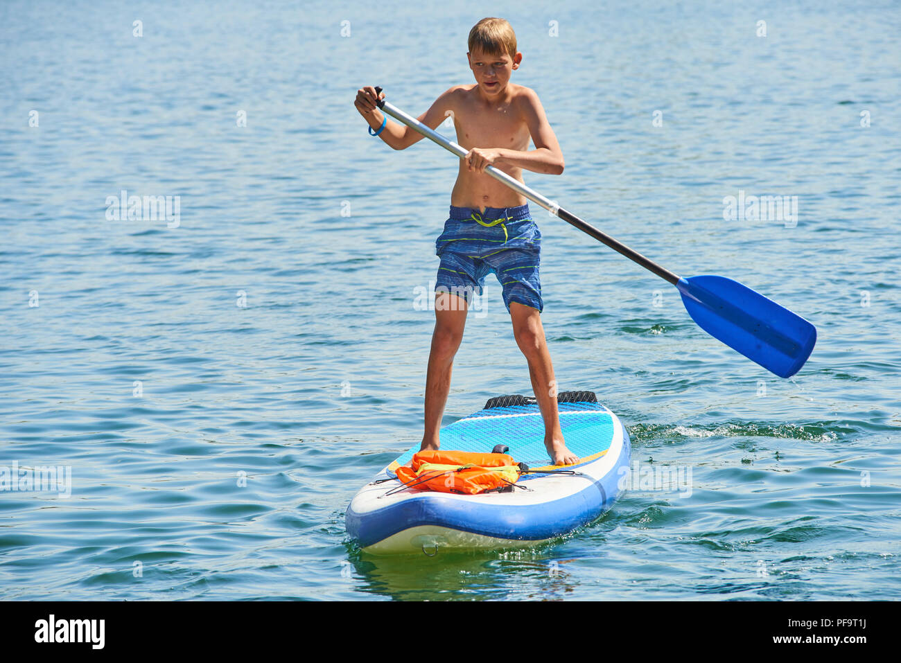 Paddle boarder. Child boy paddling on stand up paddleboard. Healthy ...