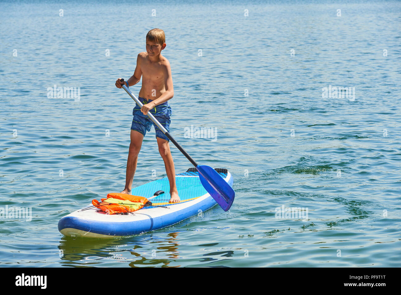 Paddle boarder. Child boy paddling on stand up paddleboard. Healthy ...