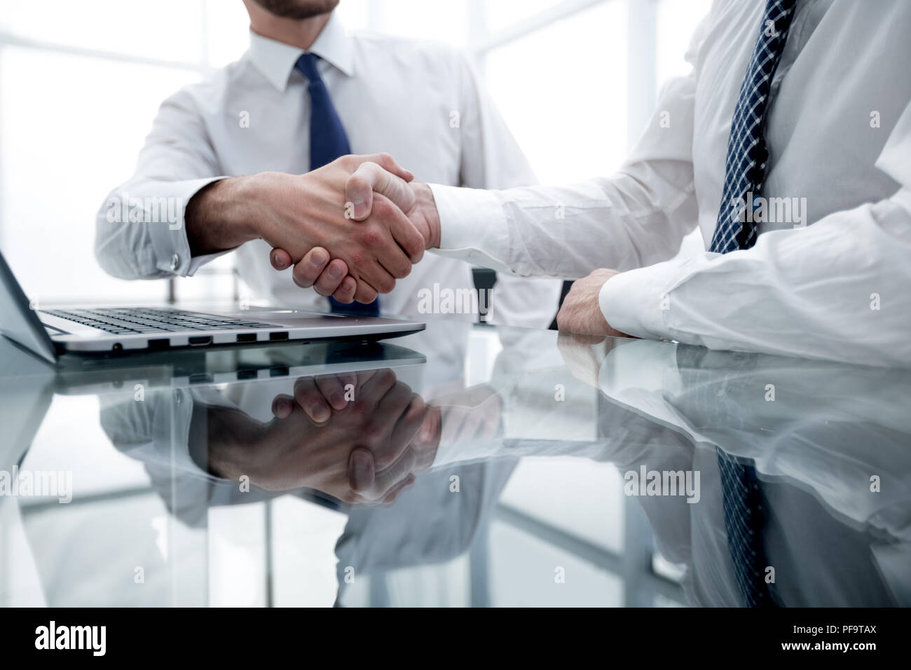 close up.colleagues shaking hands over a Desk Stock Photo - Alamy