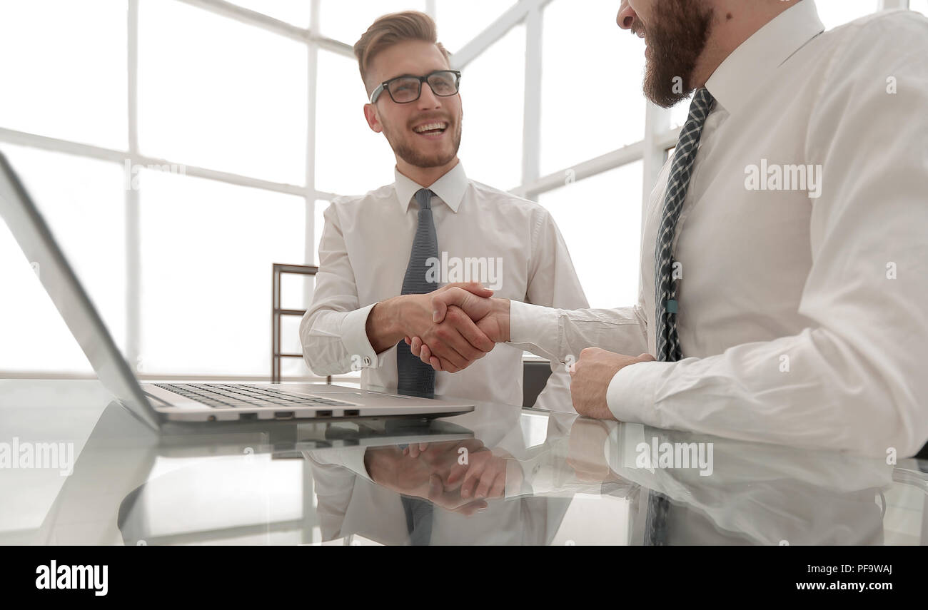 close up.colleagues shaking hands over a Desk Stock Photo - Alamy