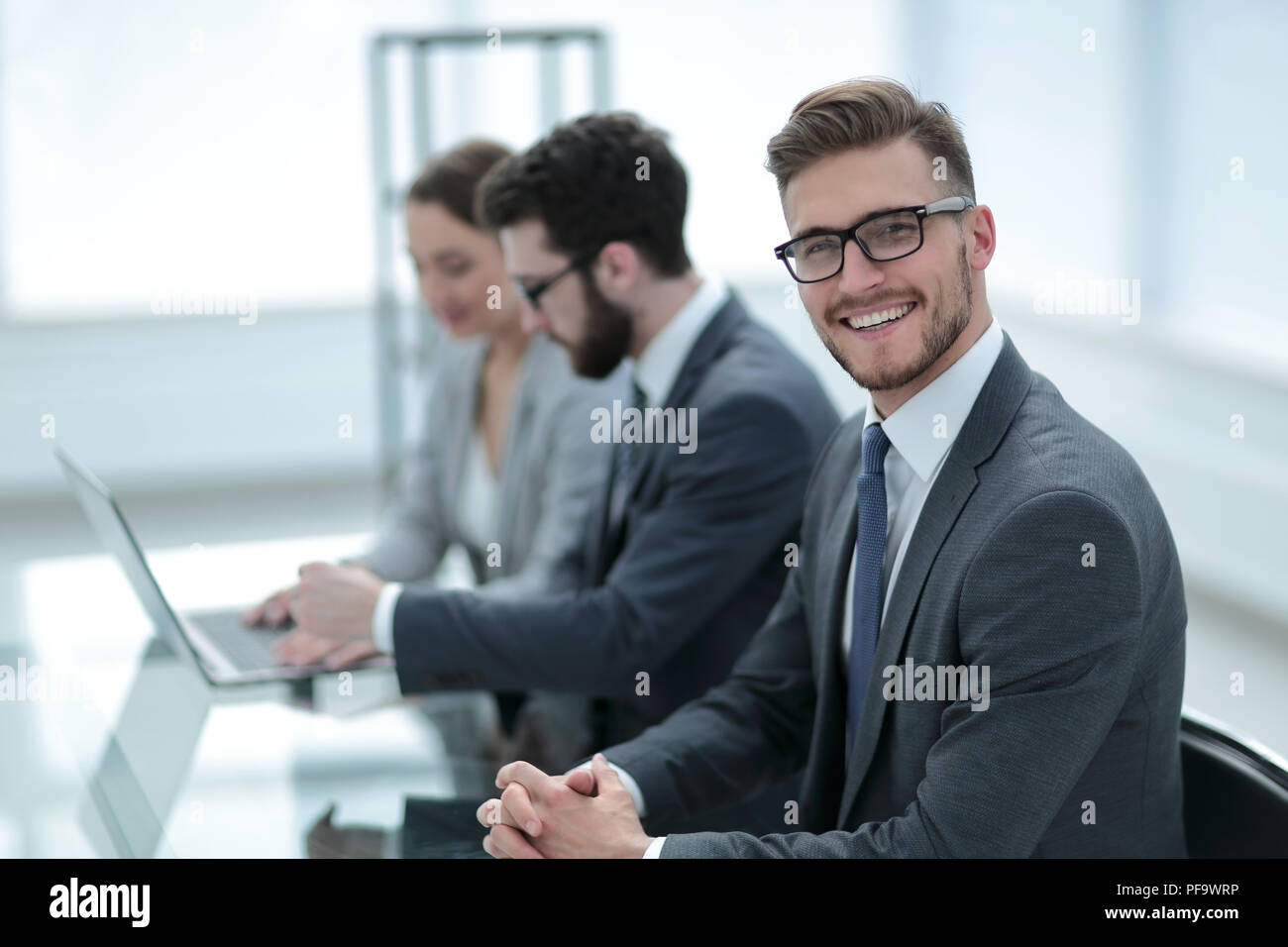 side view. smiling businessman on the background of the workplace Stock ...