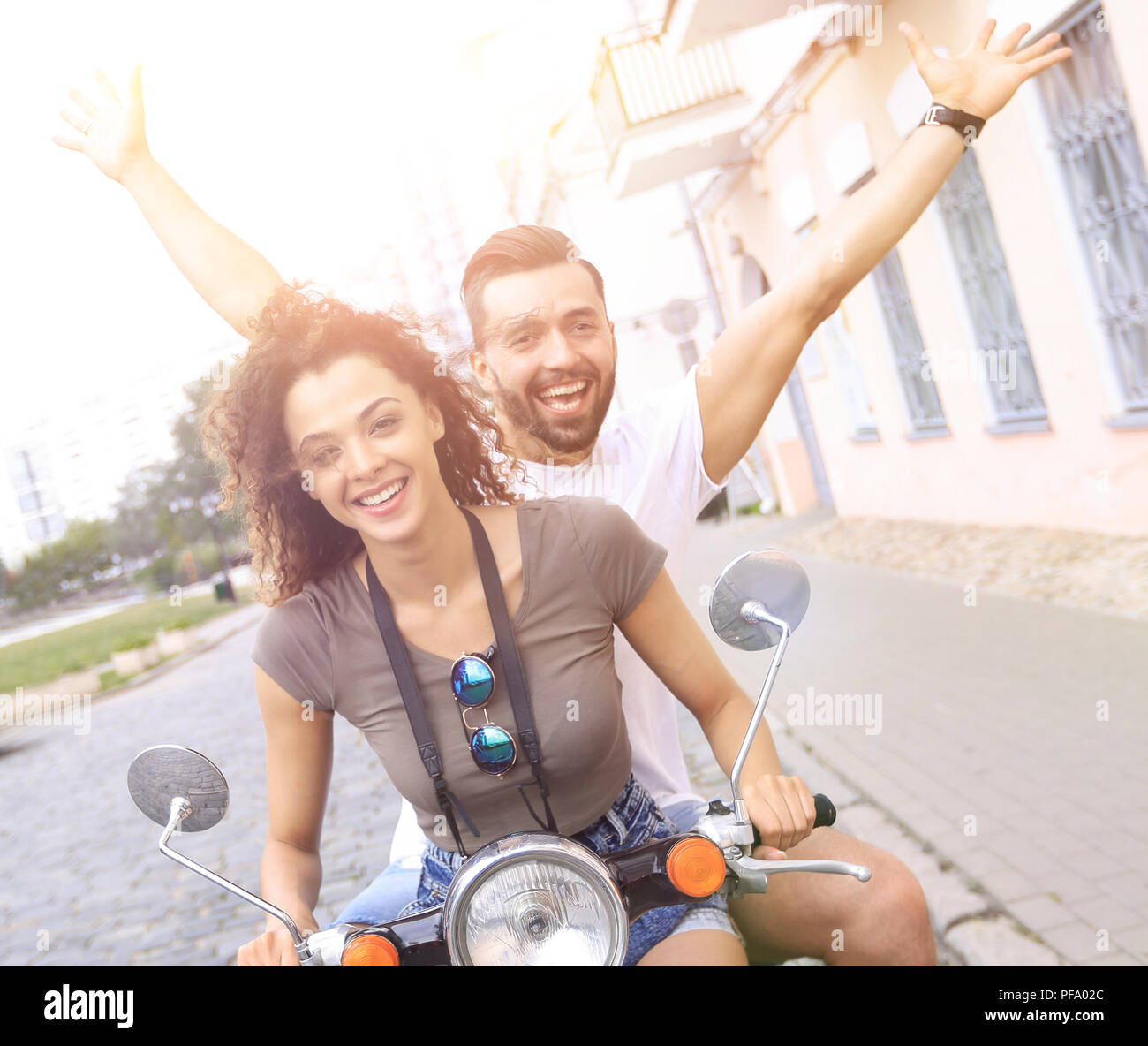 Couple riding motor scooter in old city street Stock Photo - Alamy