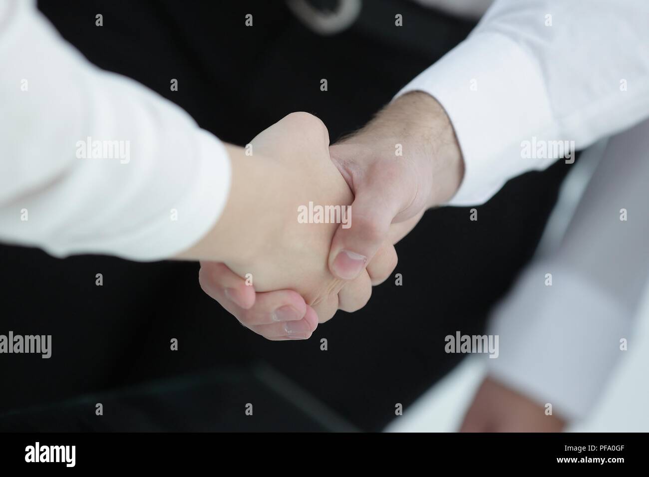 employees greet each other with a handshake near the desk Stock Photo ...