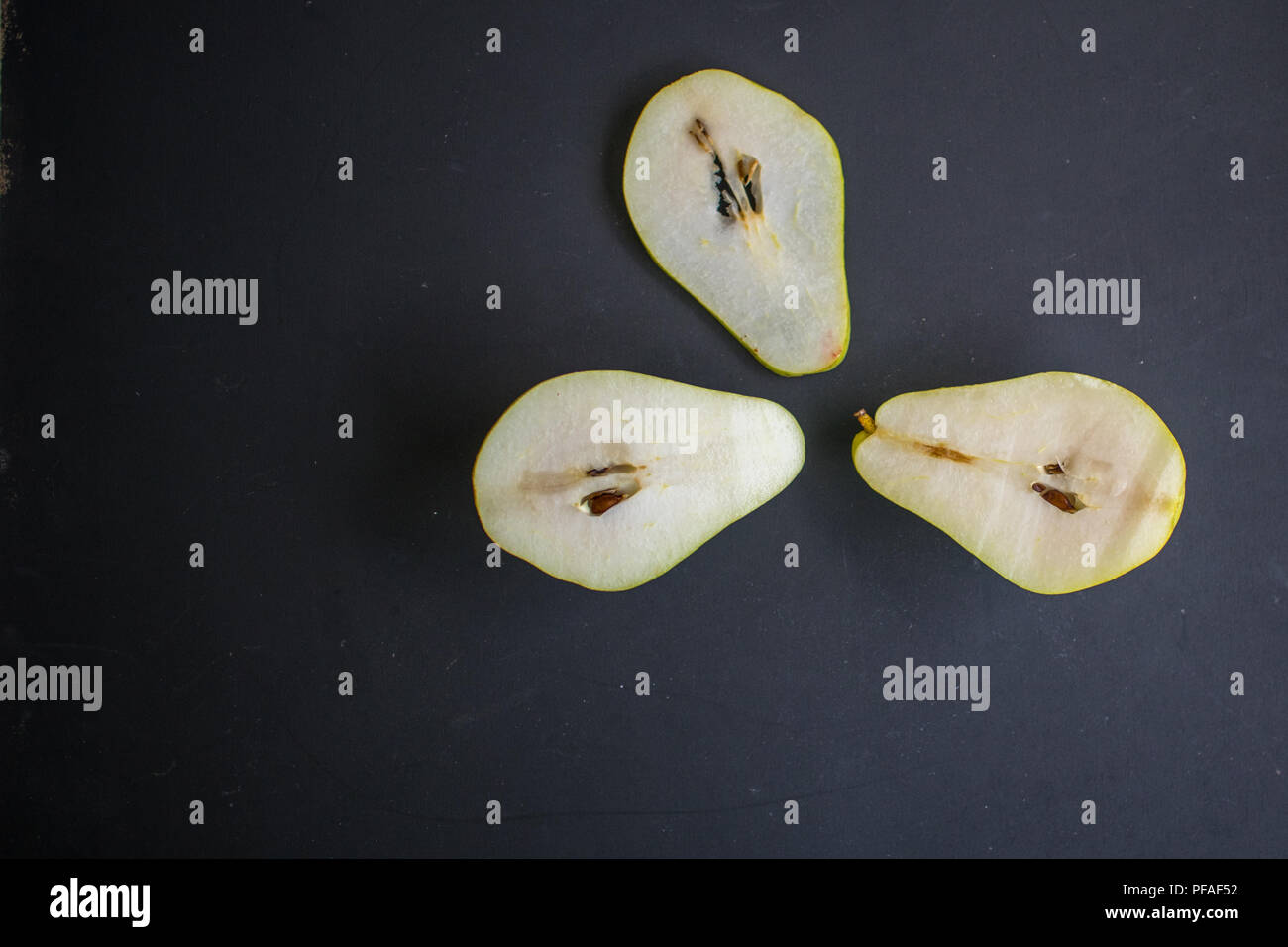 three half pears on black background Stock Photo - Alamy