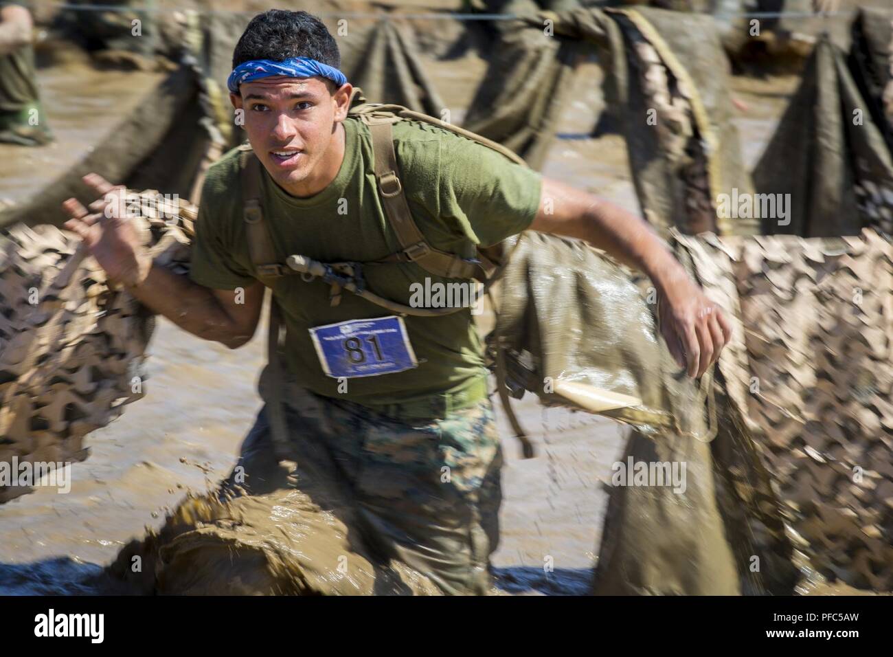 A Marine maneuvers through a mud pit during the 2018 Mud Run Commanding ...